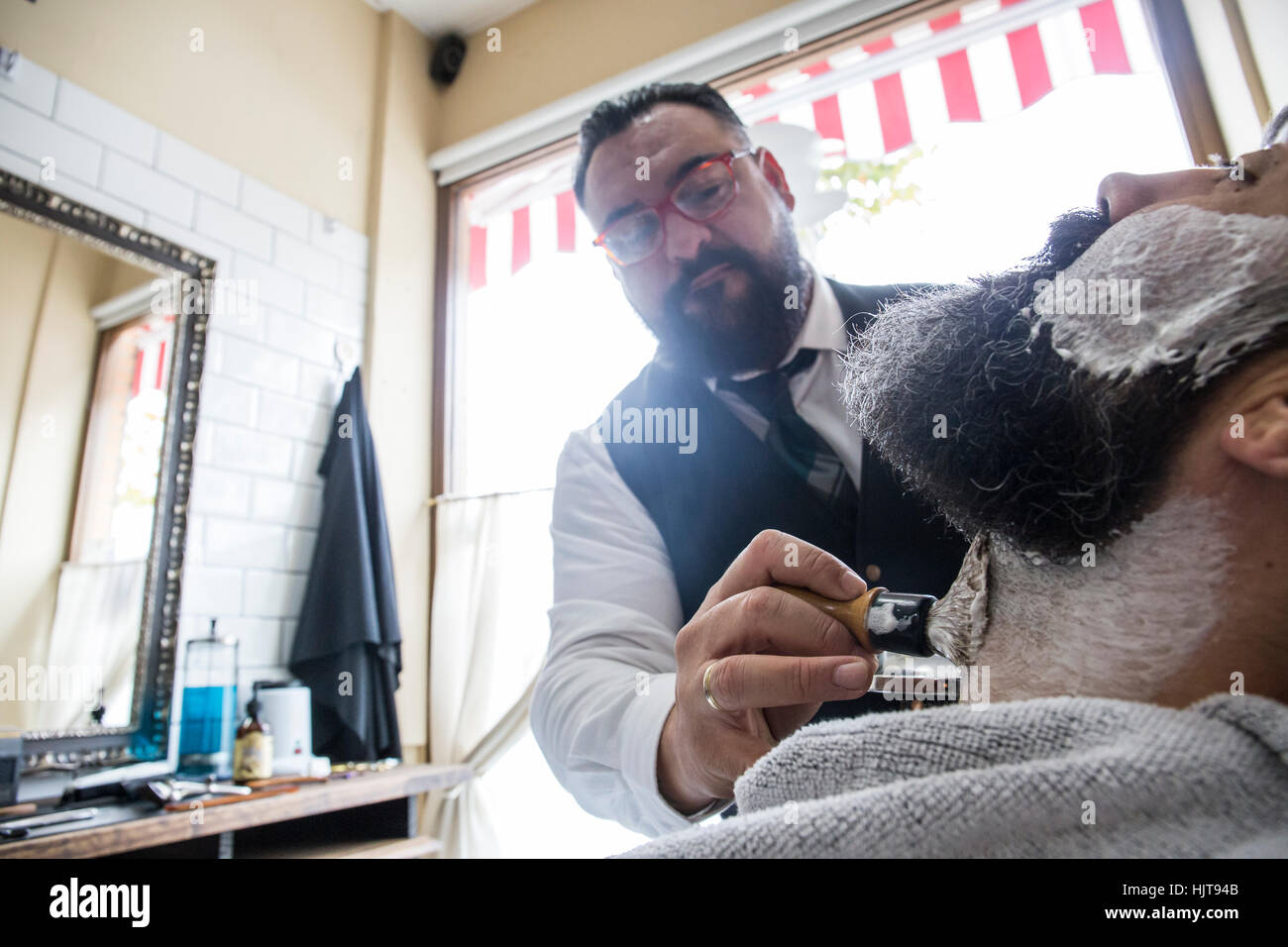 Barber putting shaving foam in man's beard Stock Photo - Alamy