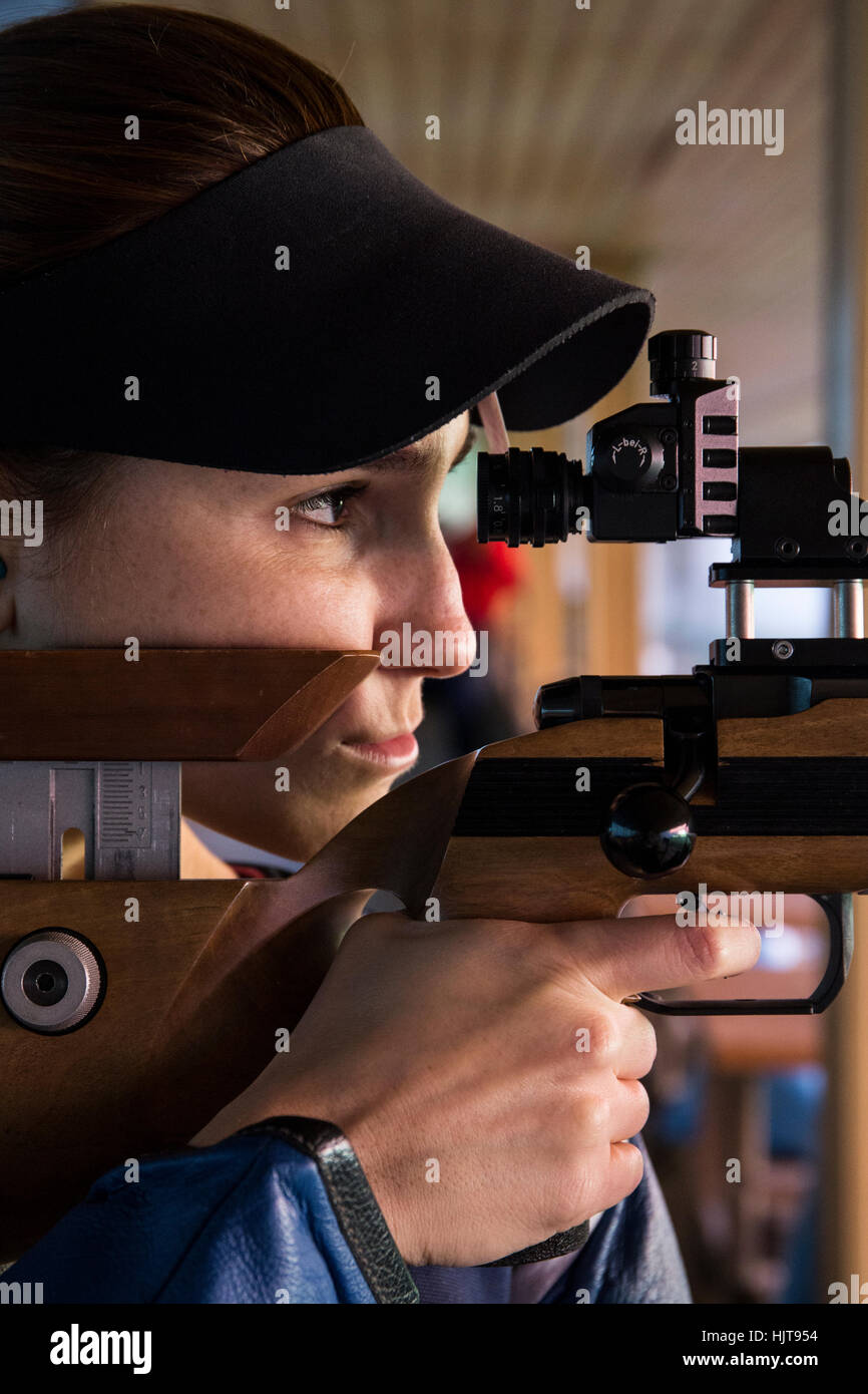 Woman with a sporting rifle aiming in a shooting range Stock Photo - Alamy