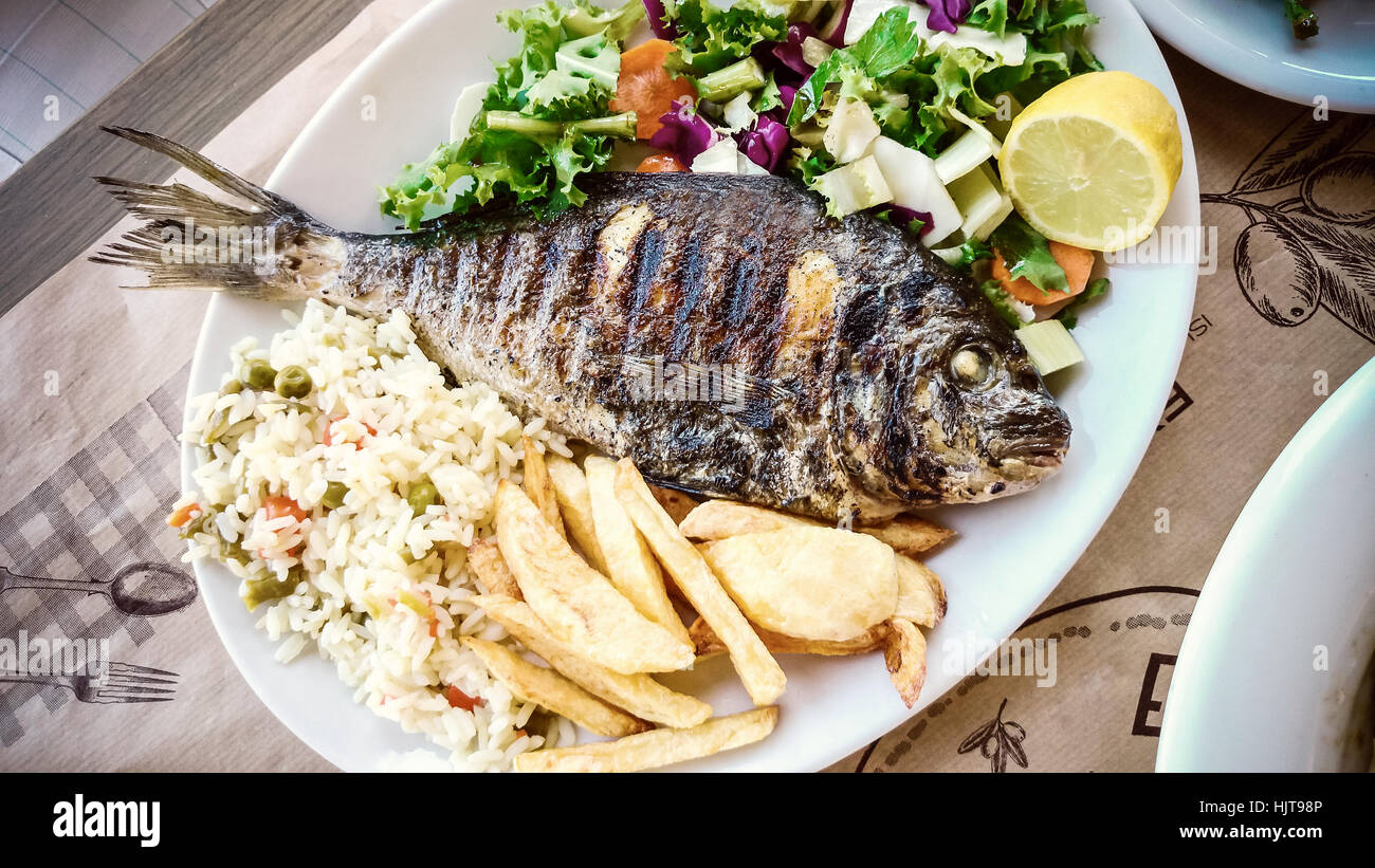 Bream with potato, rice and salad, mediterranean food Stock Photo - Alamy