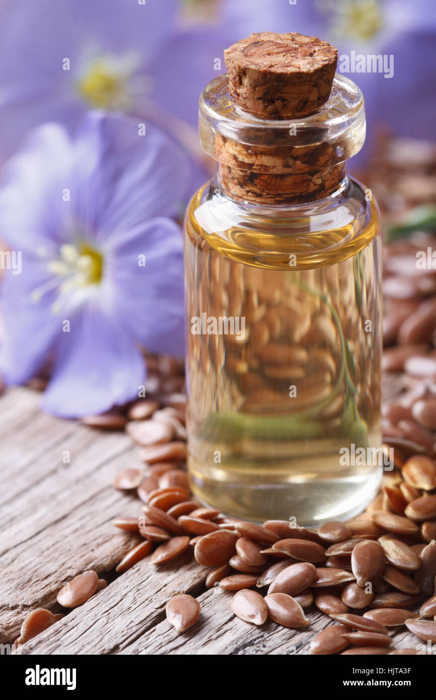 flax oil in a glass bottle macro on a background of flowers and seeds ...