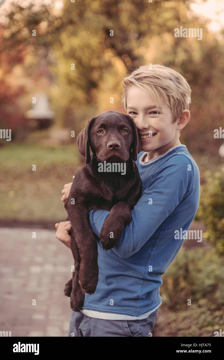 Boy holding Labrador Retriever Stock Photo - Alamy