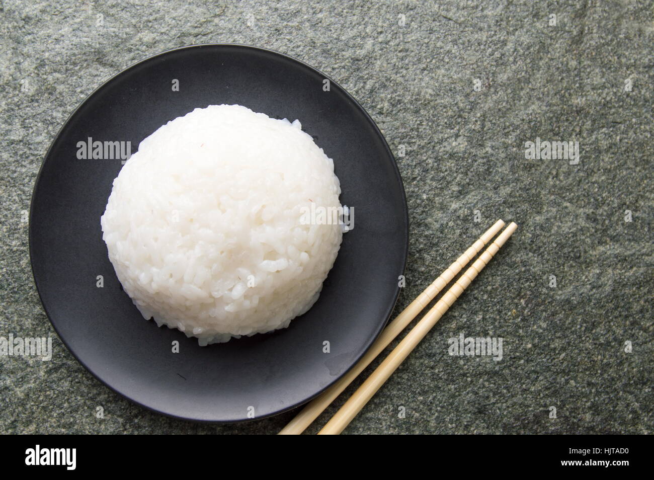 ball of rice in a black plate with chopsticks Stock Photo - Alamy