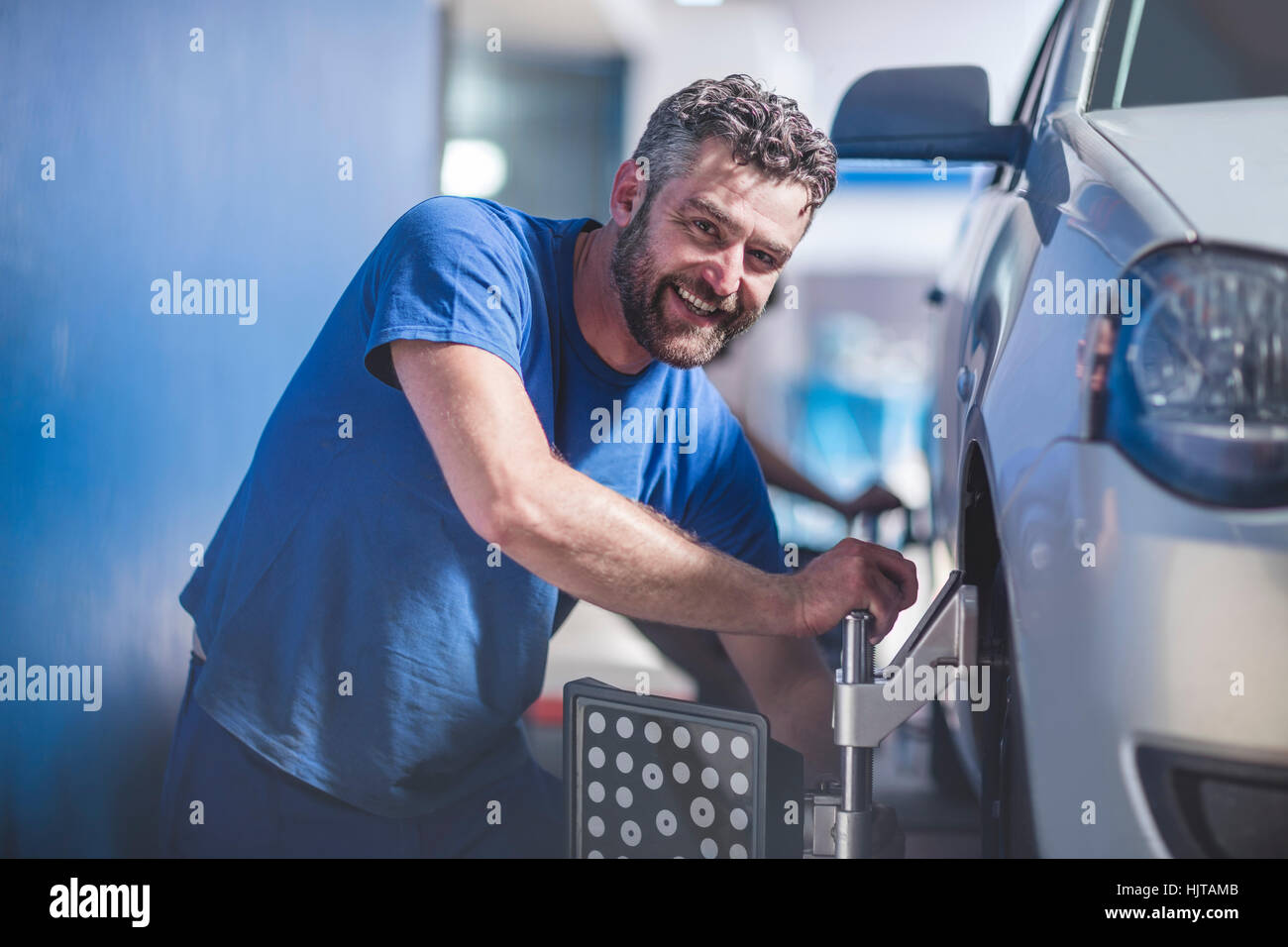 Smiling car mechanic in a workshop Stock Photo - Alamy