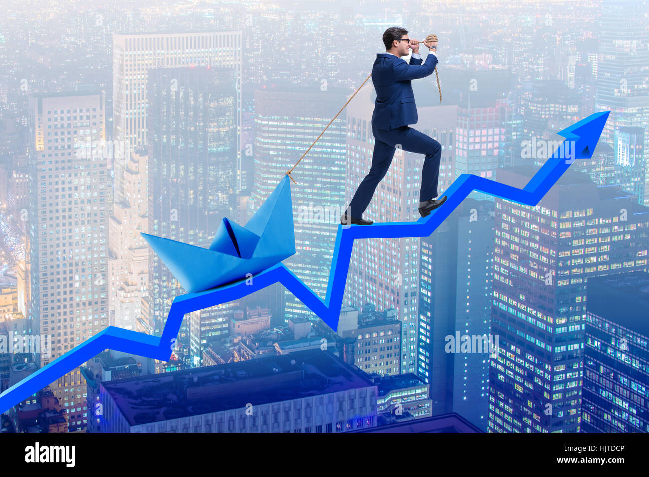 Businessman pulling boat over line chart Stock Photo - Alamy