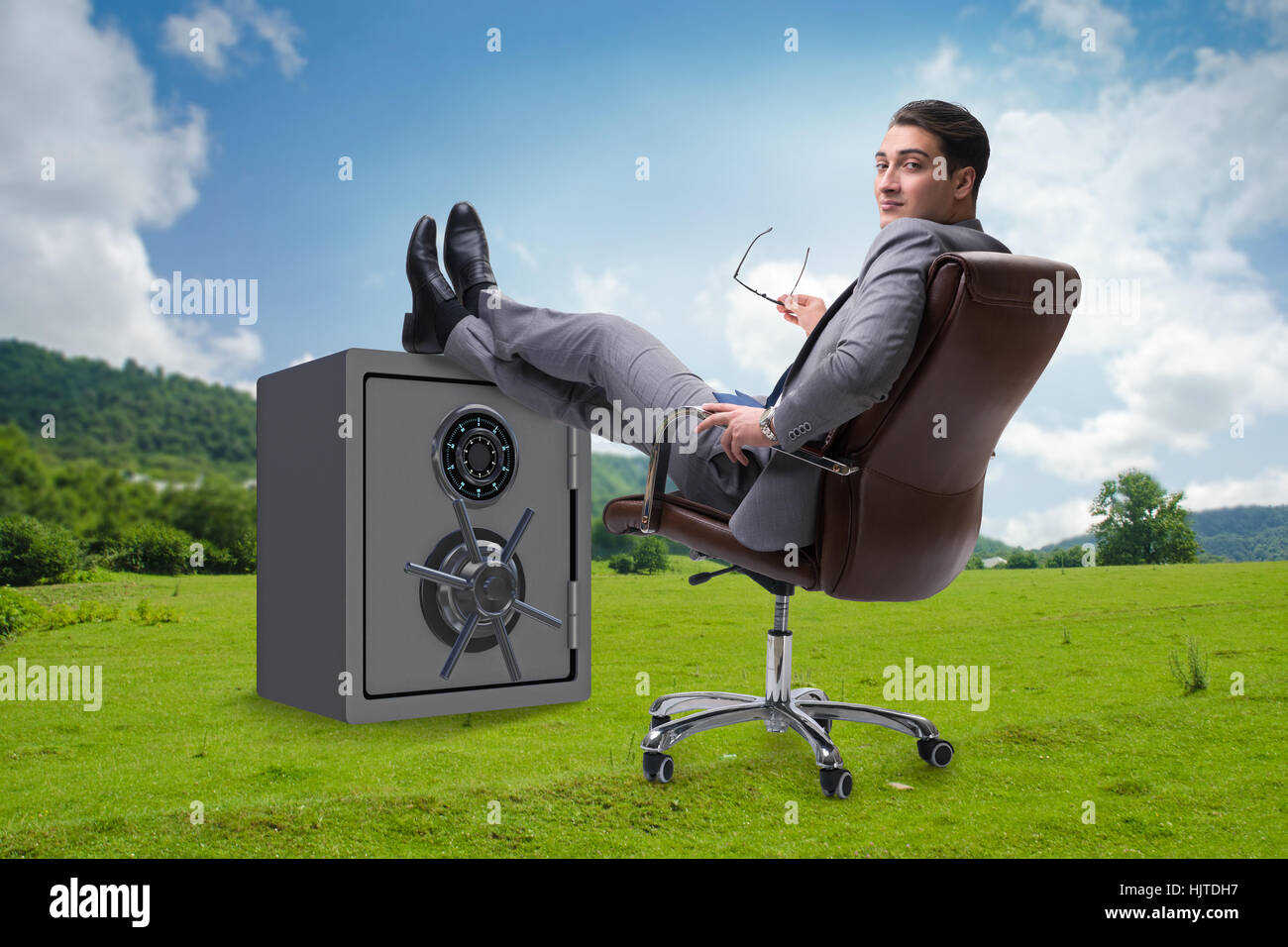 Businessman resting putting leg on safe Stock Photo - Alamy
