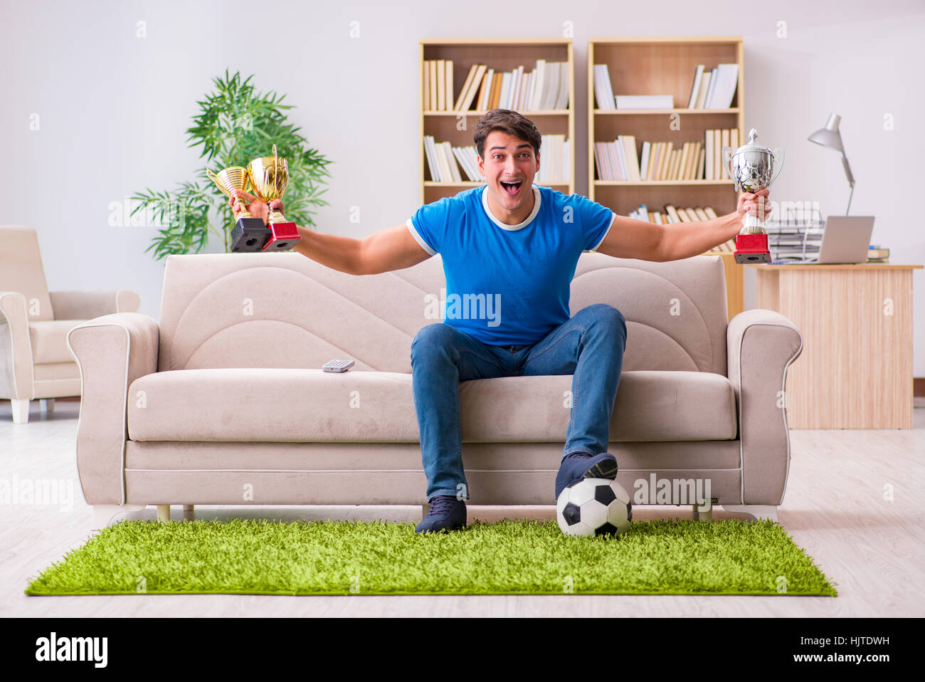 Man watching football at home sitting in couch Stock Photo - Alamy