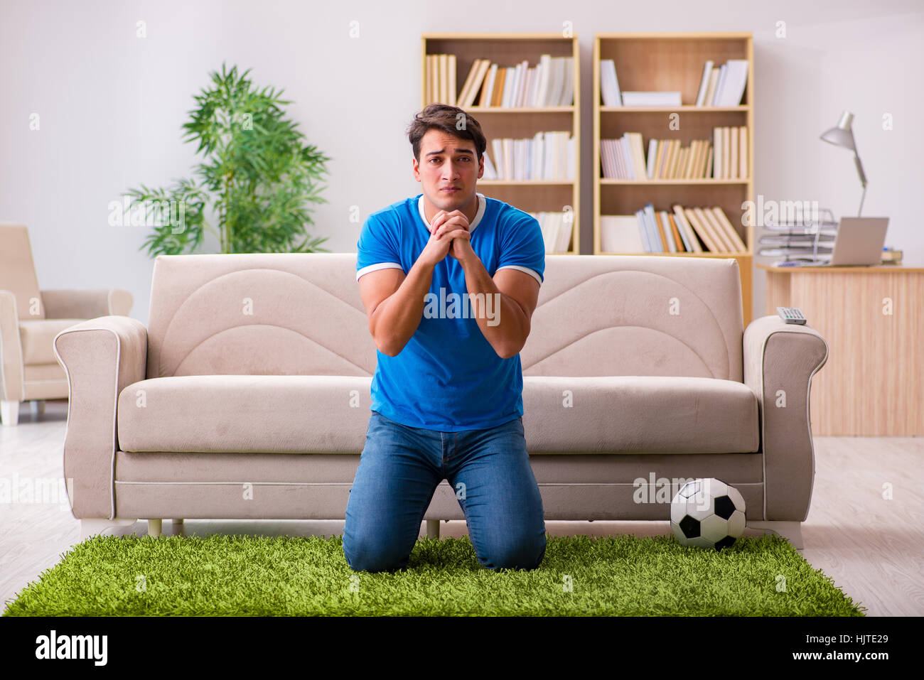 Man watching football at home sitting in couch Stock Photo - Alamy