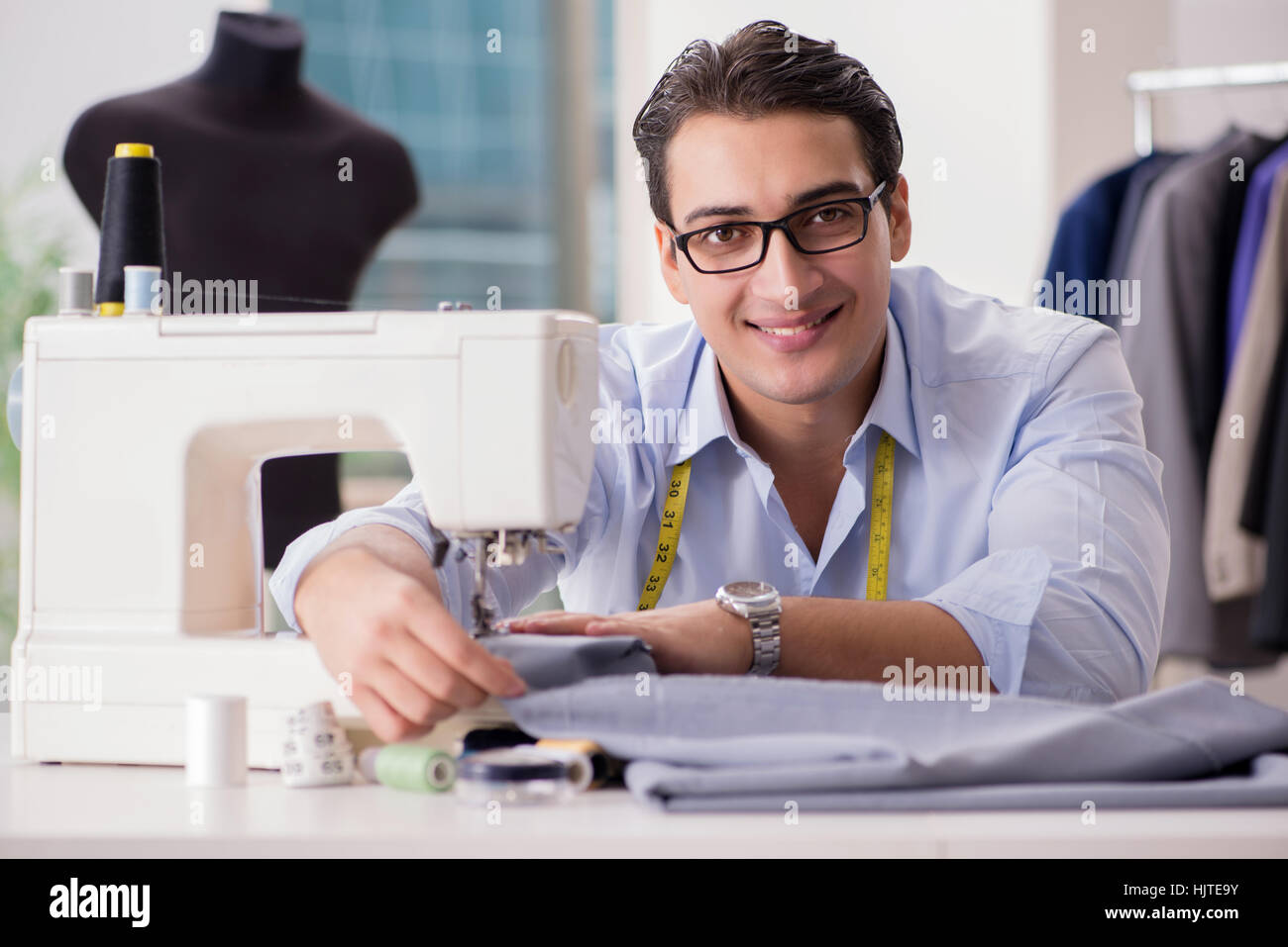 Young man tailor working on new clothing Stock Photo - Alamy