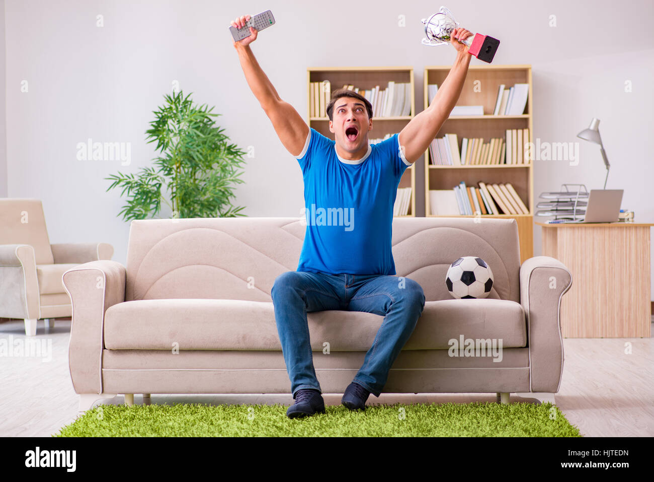Man watching football at home sitting in couch Stock Photo - Alamy