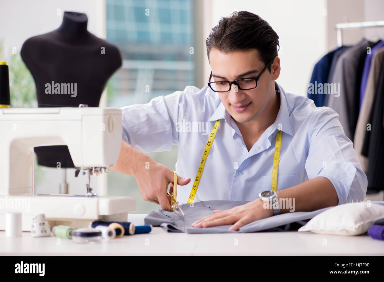 Young man tailor working on new clothing Stock Photo - Alamy