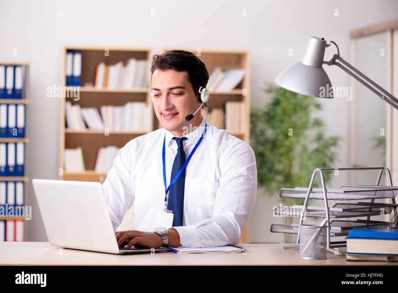 Handsome customer service clerk with headset Stock Photo - Alamy