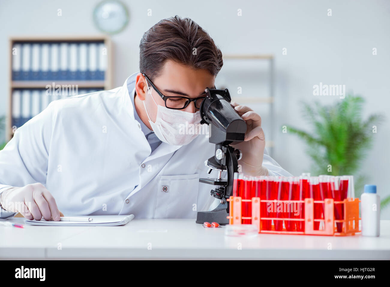 Young doctor working in the lab with microscope Stock Photo - Alamy