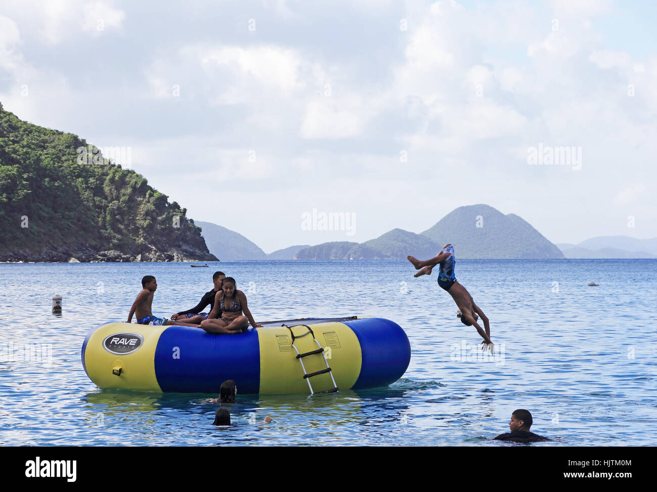 Local children playing and diving off large inflatable platform, Cane ...
