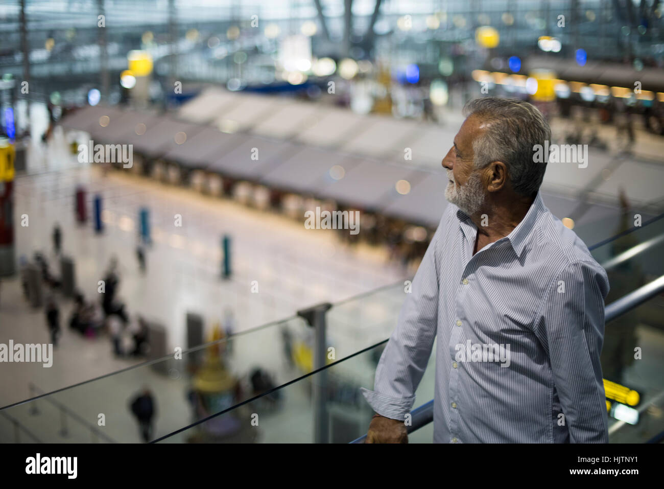 Man staring at the airport crowd downstairs Stock Photo - Alamy