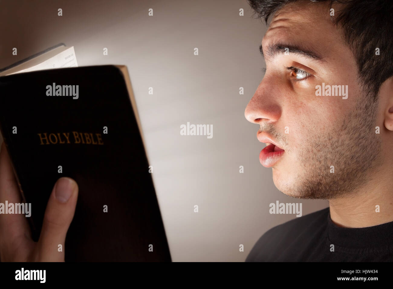 Young man astonished and intrigued by open Bible Stock Photo - Alamy