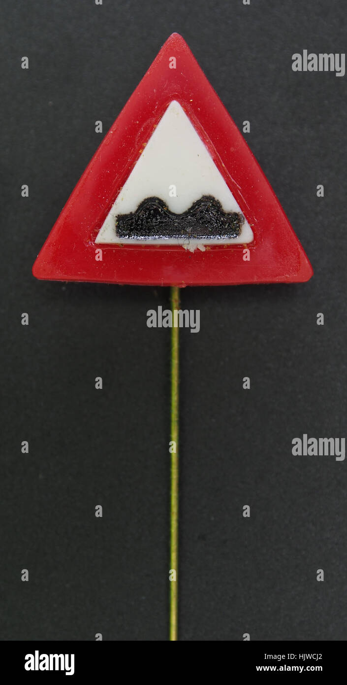 A vintage advertising pin featuring a traffic sign symbolizing poor ...