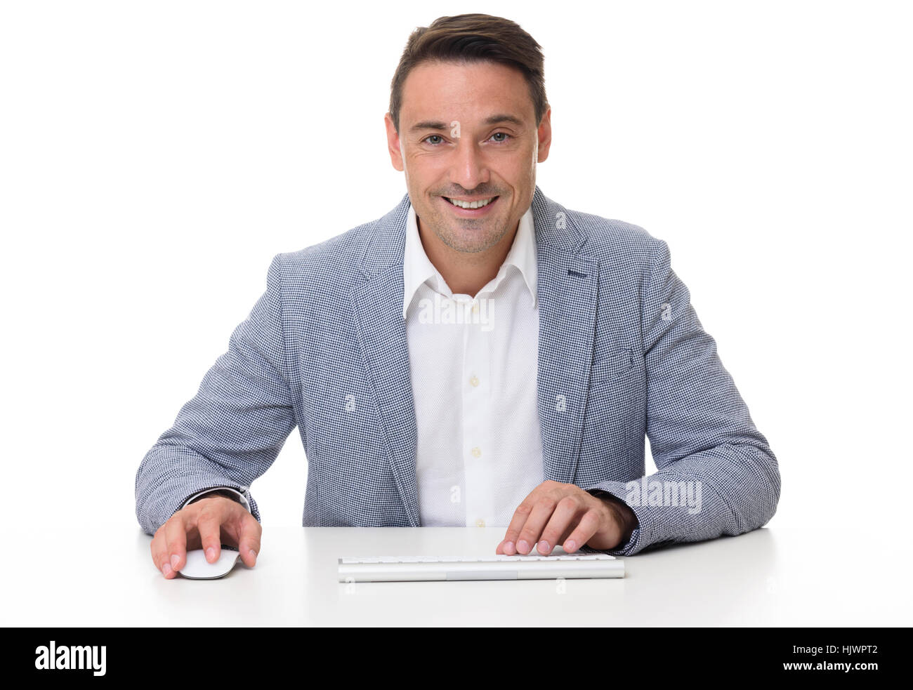 Handsome businessman sitting at desk, working on computer. isolated on ...
