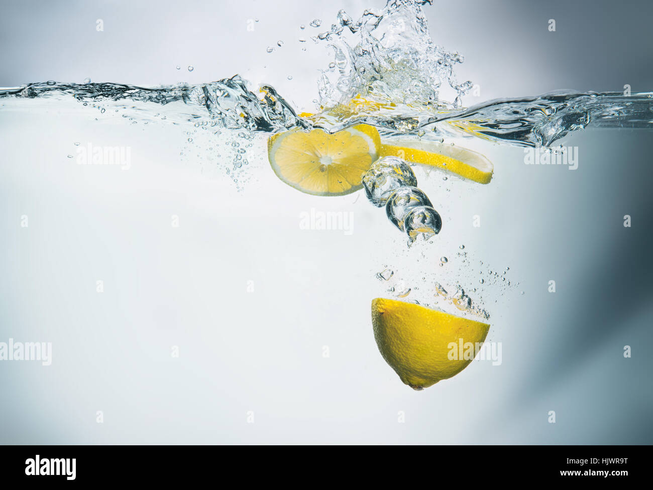 Fresh lemon dropped into water with splash Stock Photo - Alamy