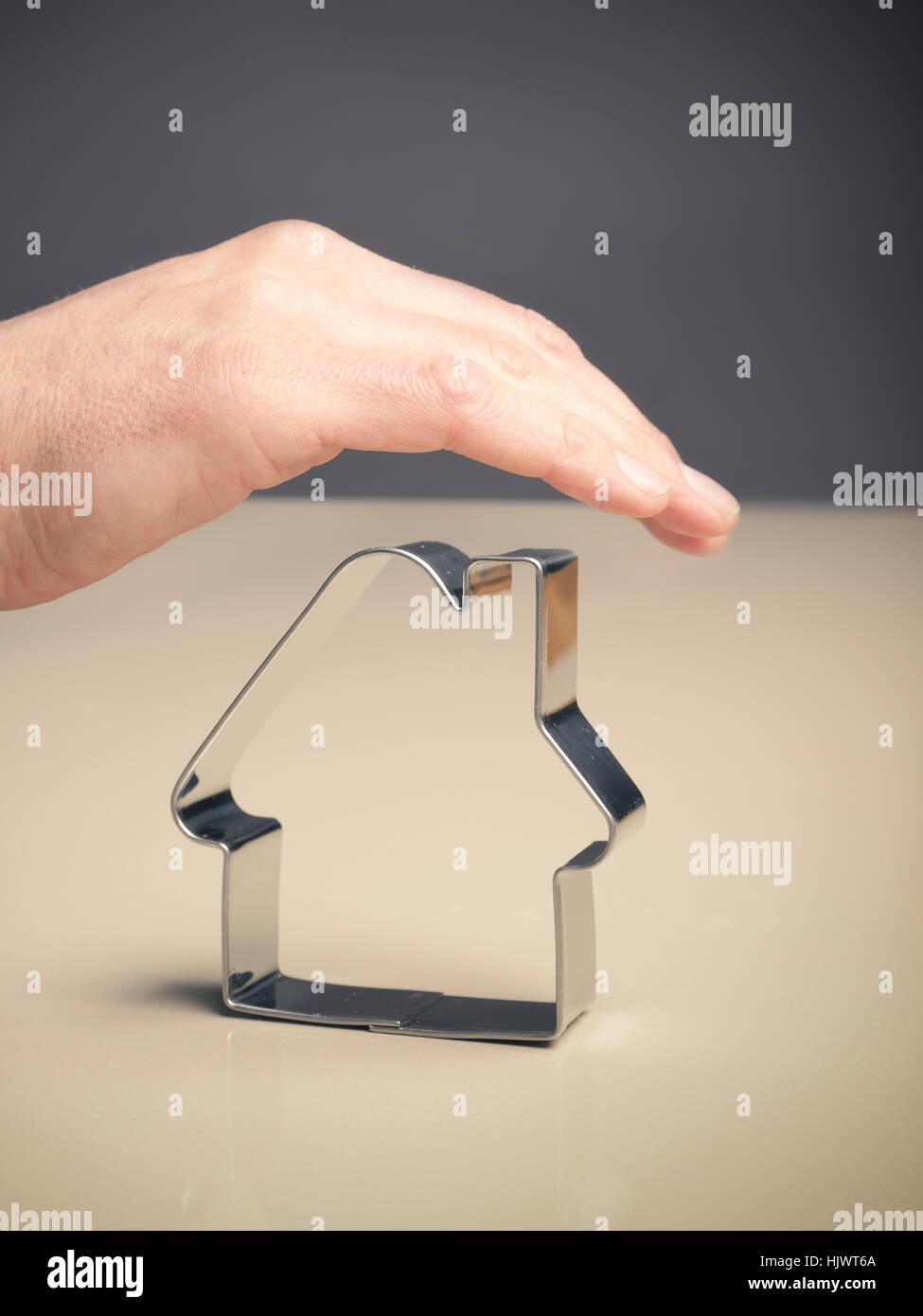 Hand protecting a house shape, safety concept image Stock Photo - Alamy
