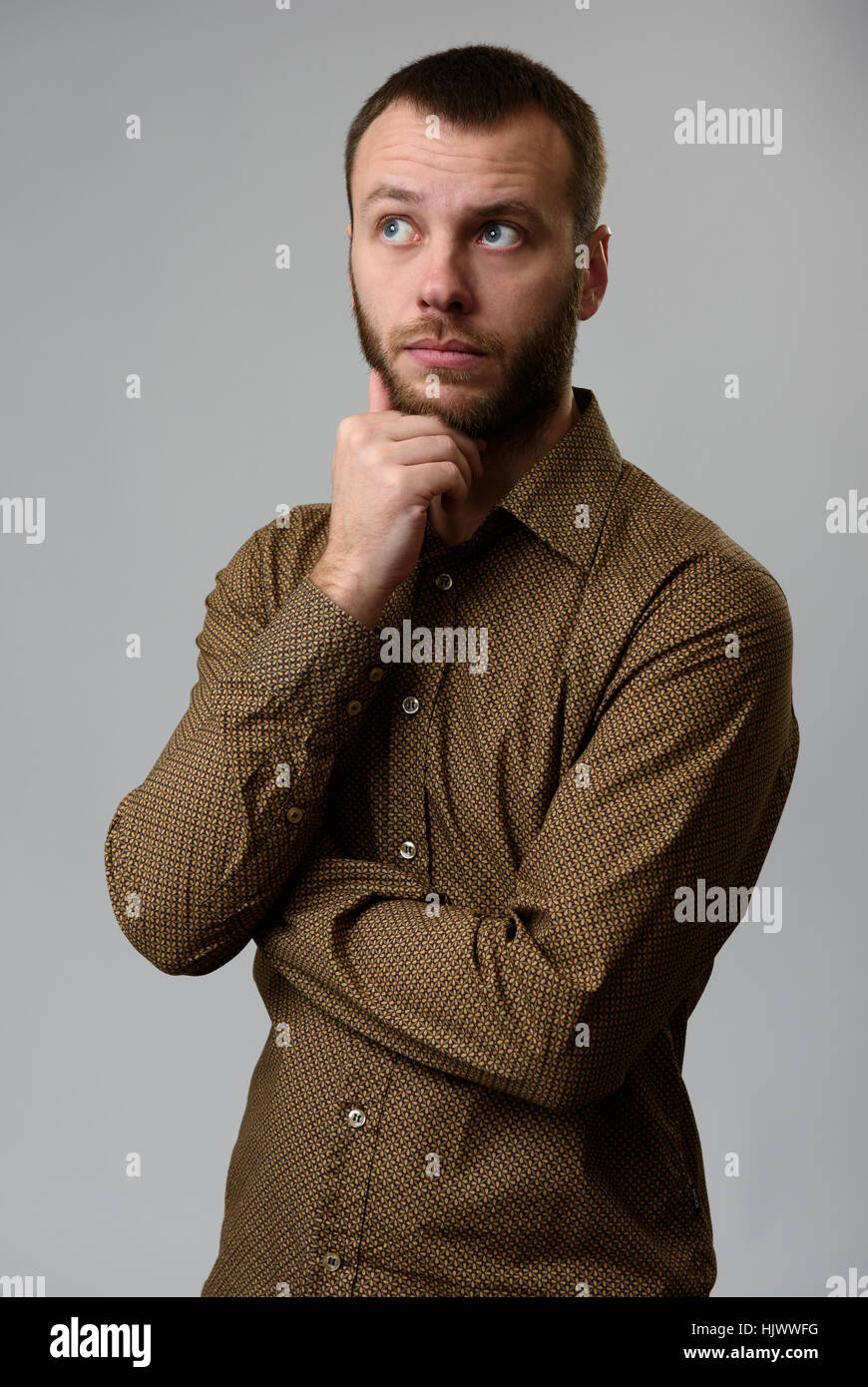 student man thinking and looking up. Gray background Stock Photo - Alamy