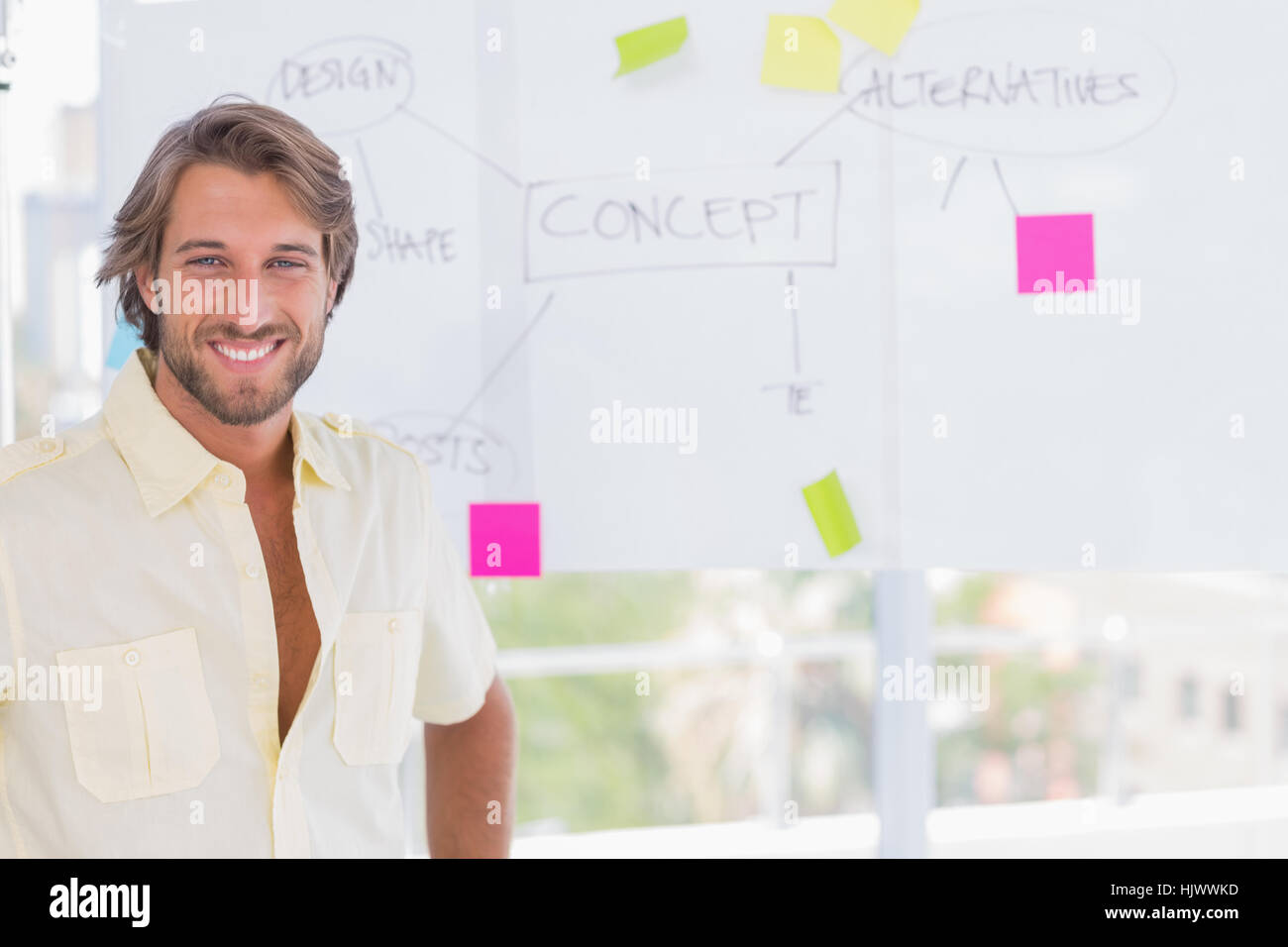 Handsome man standing in front of whiteboard with creative flowchart ...