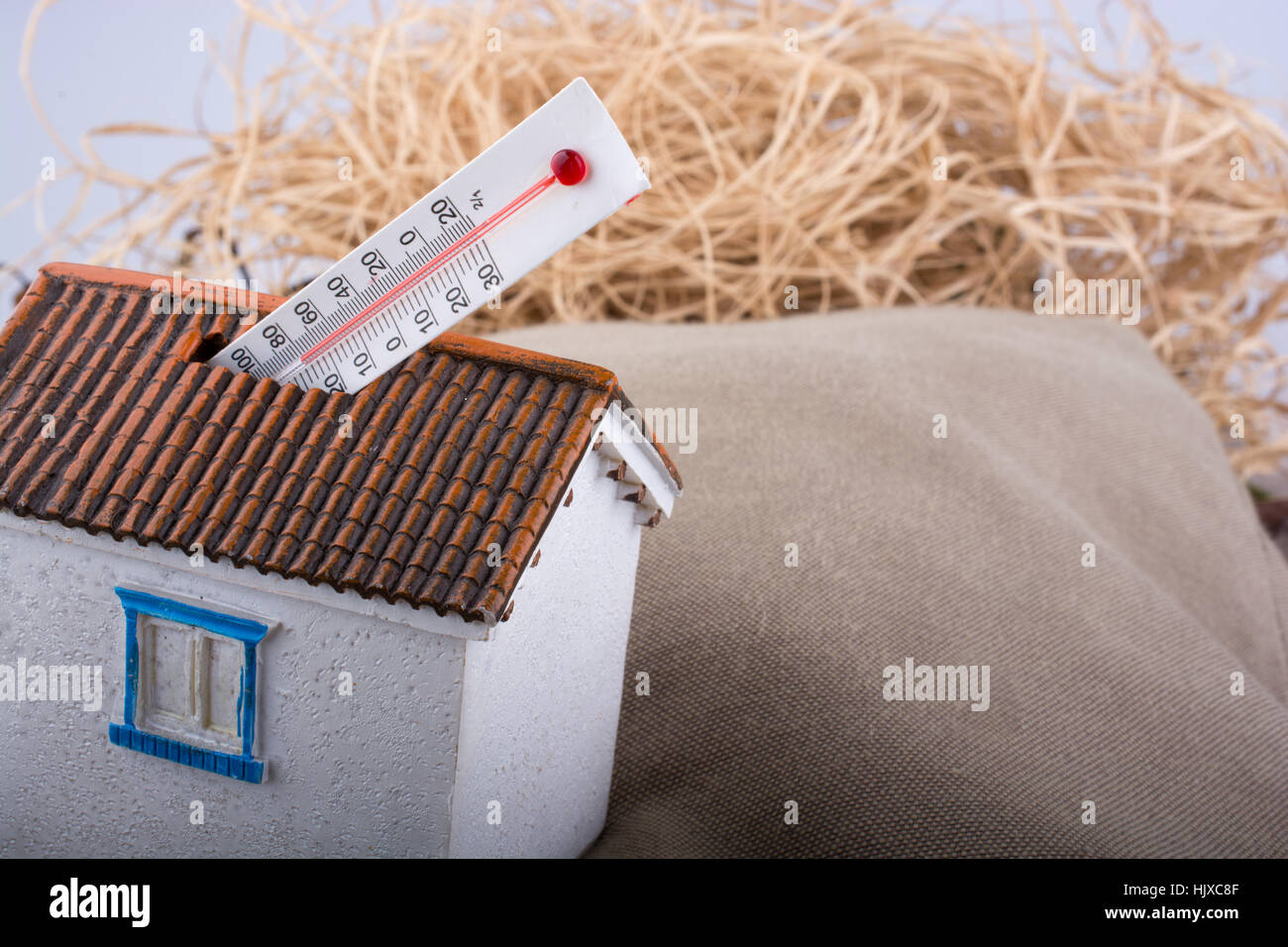 Thermometer measuring high temperature placed on a little model house ...