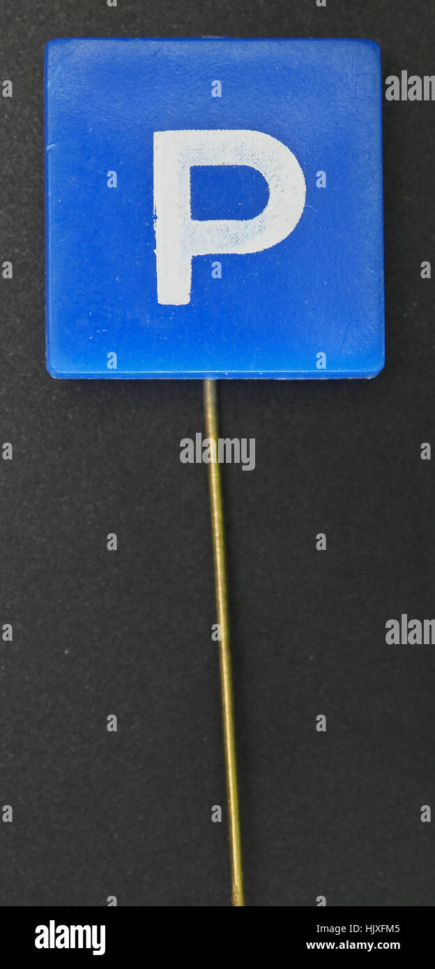 A vintage advertising pin featuring a parking sign, promoting parking ...