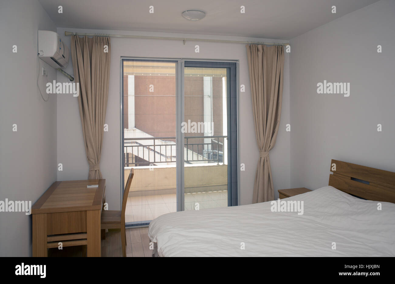 Bedroom in apartment with fly screens over windows and wall mounted air ...