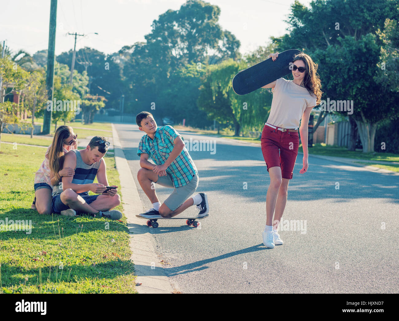 Group of young people having fun together outdoors in evening light ...