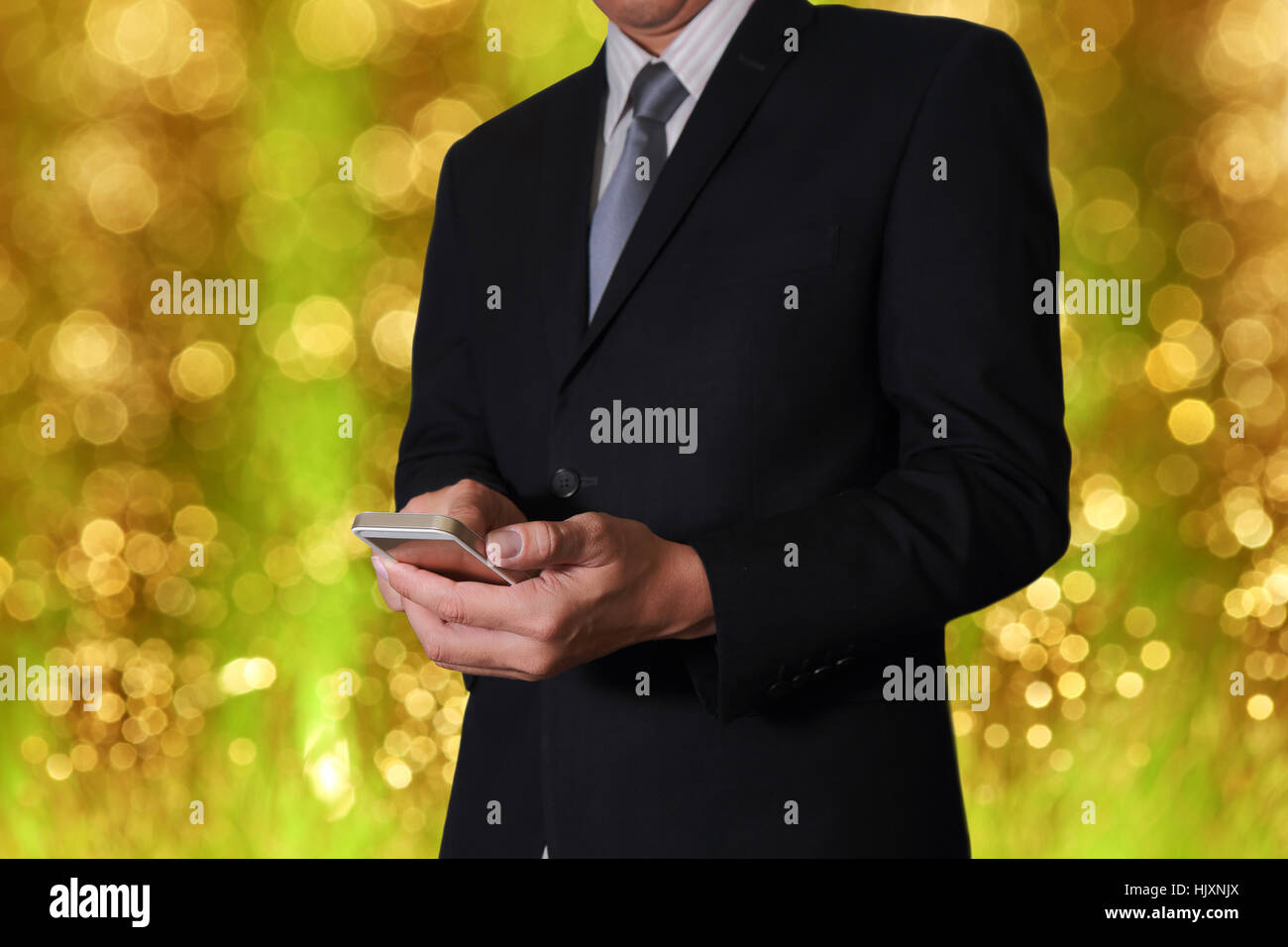 Business man hand touch screen smart phone and abstract gold yellow ...