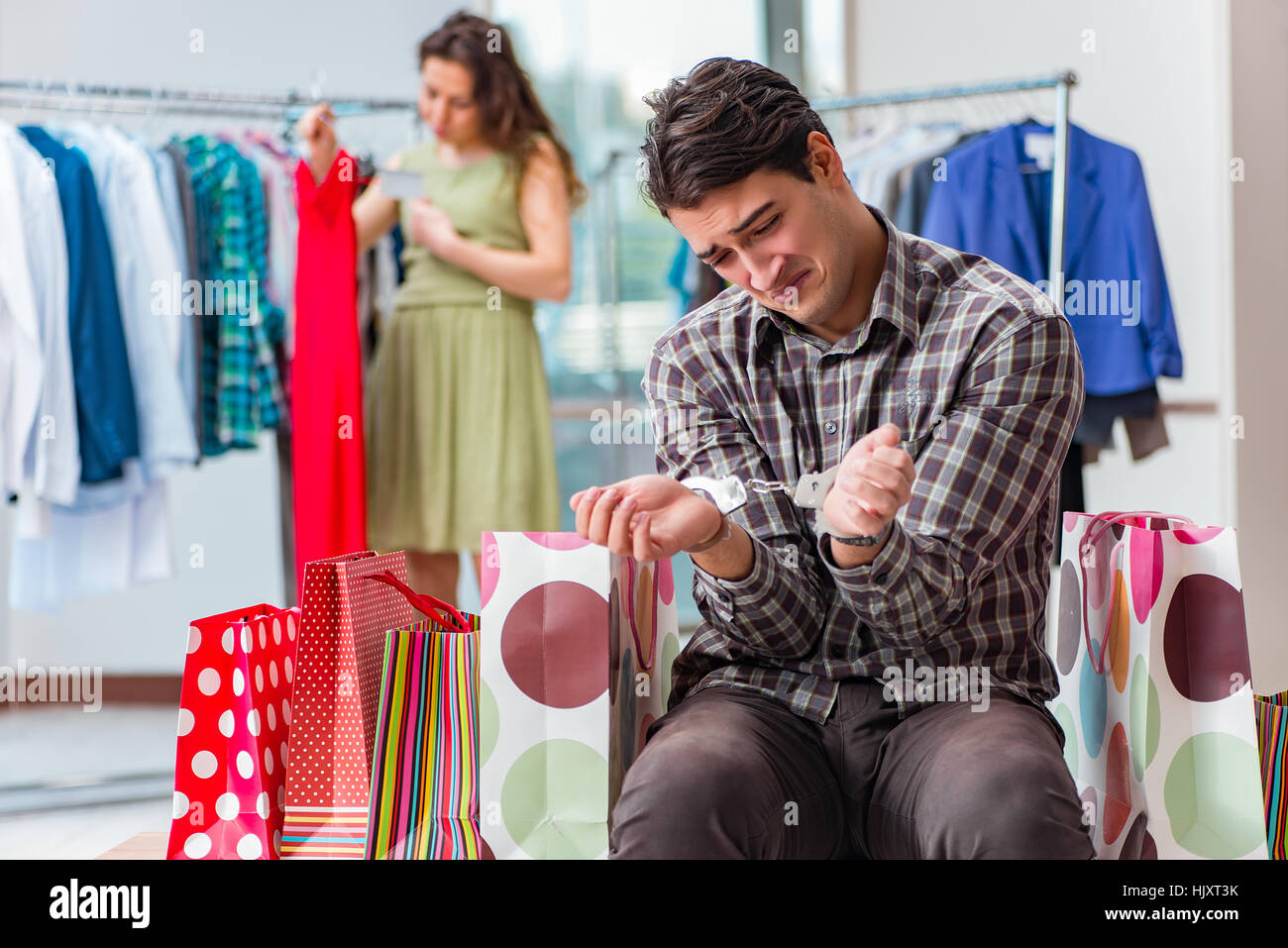 Man fed up with wife shopping in shop Stock Photo - Alamy