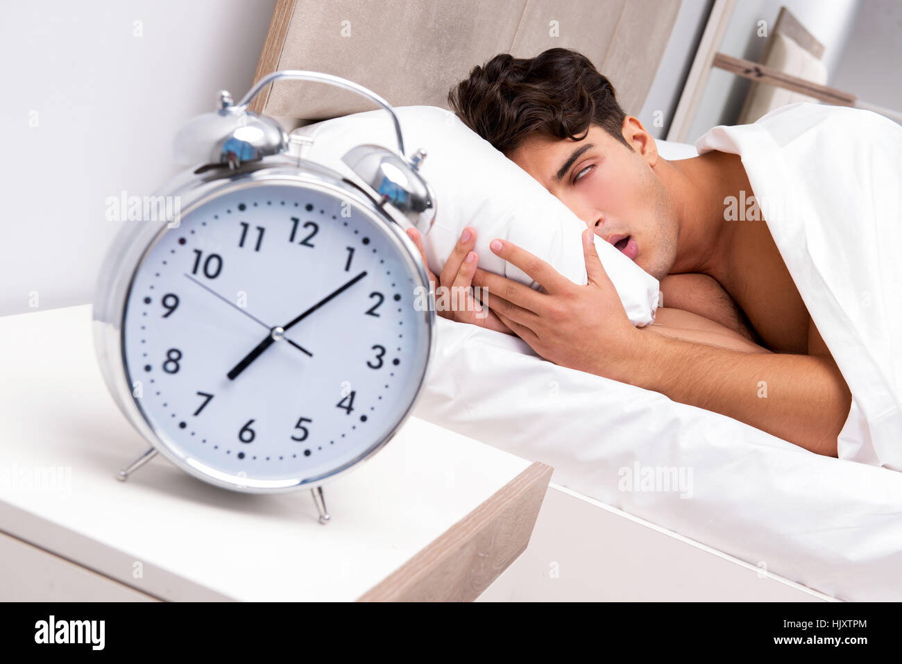 Young man having trouble waking up in the morning Stock Photo - Alamy
