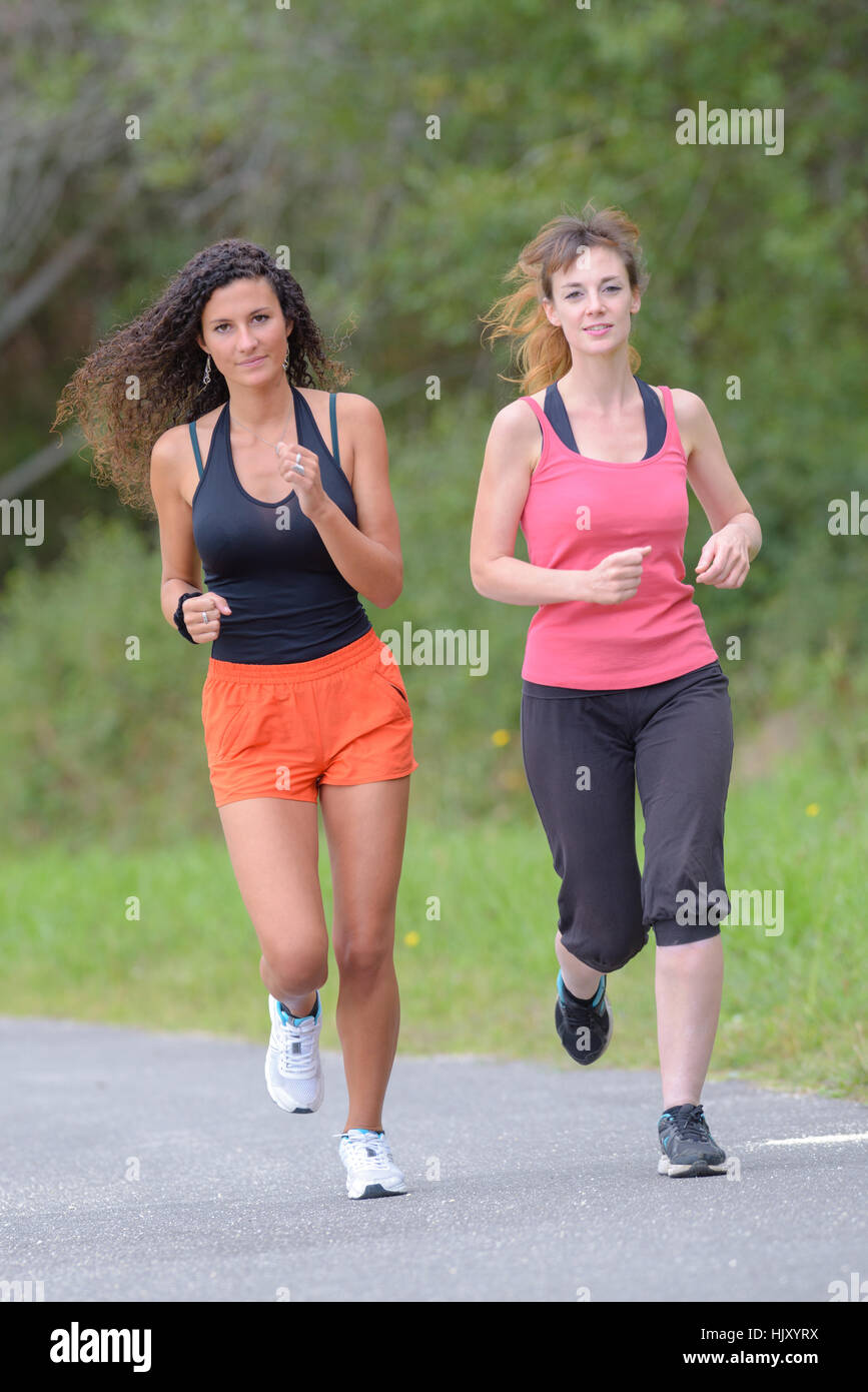 Two young women running Stock Photo - Alamy