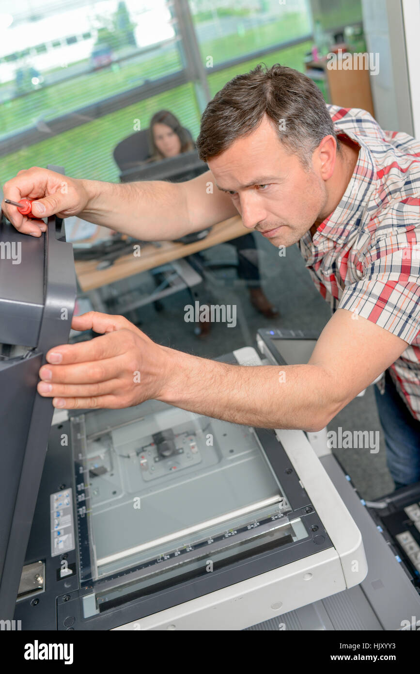 Man trying to repair a printer Stock Photo - Alamy