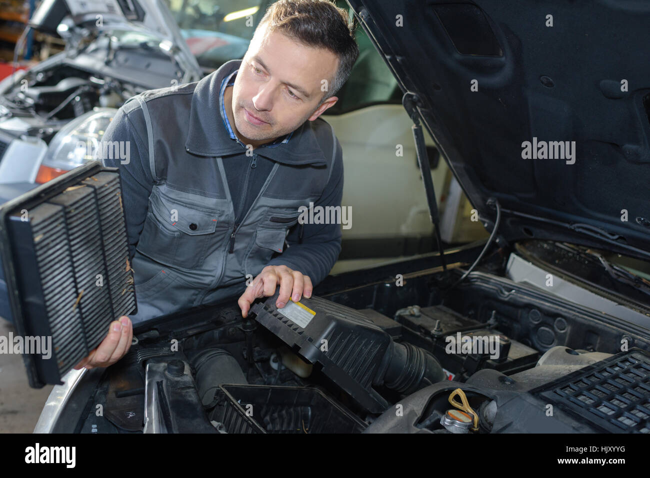 mechanic changing car air filter Stock Photo - Alamy