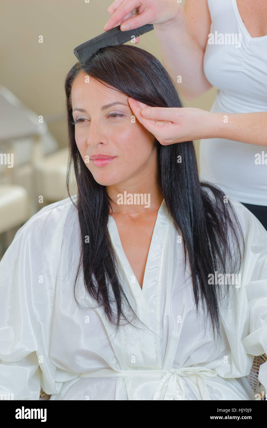 Stylist brushing a client's hair Stock Photo - Alamy
