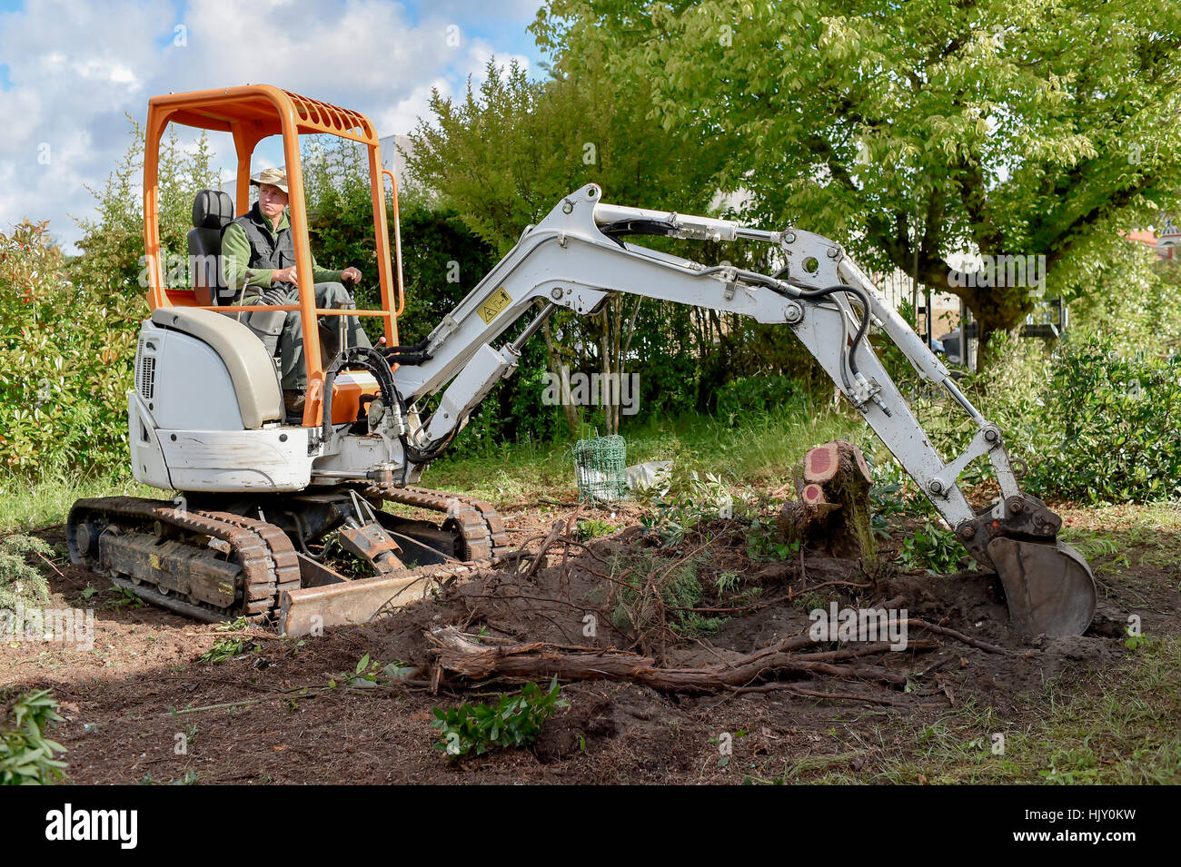 Man using a digger in the garden Stock Photo - Alamy