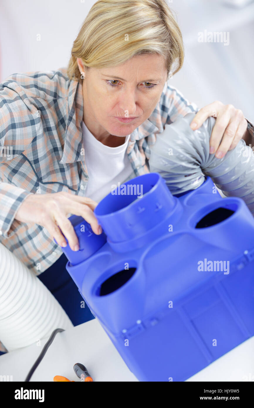 blonde woman installing new ac system Stock Photo - Alamy