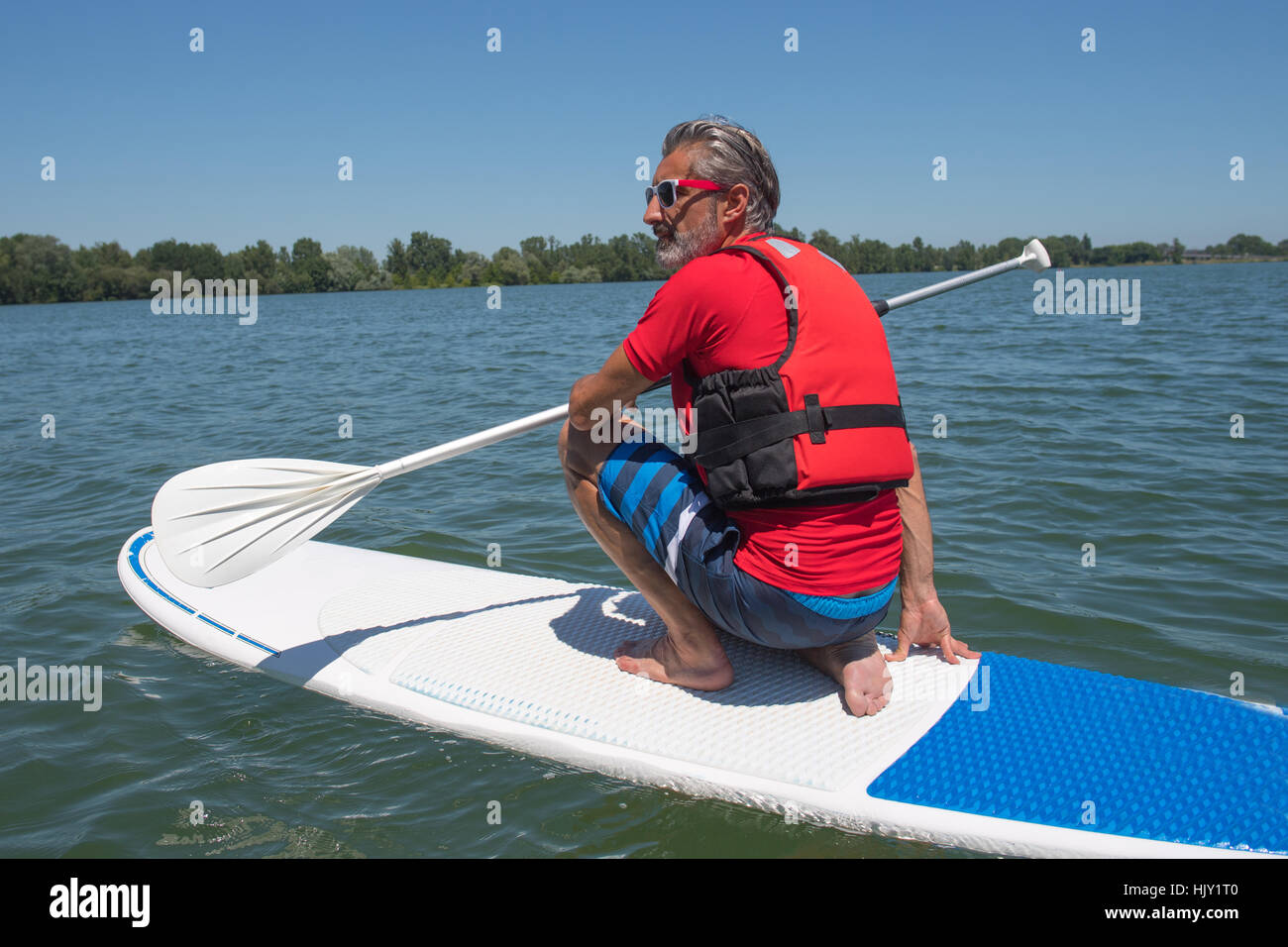 Man sitting on stand up paddleboard hi-res stock photography and images ...
