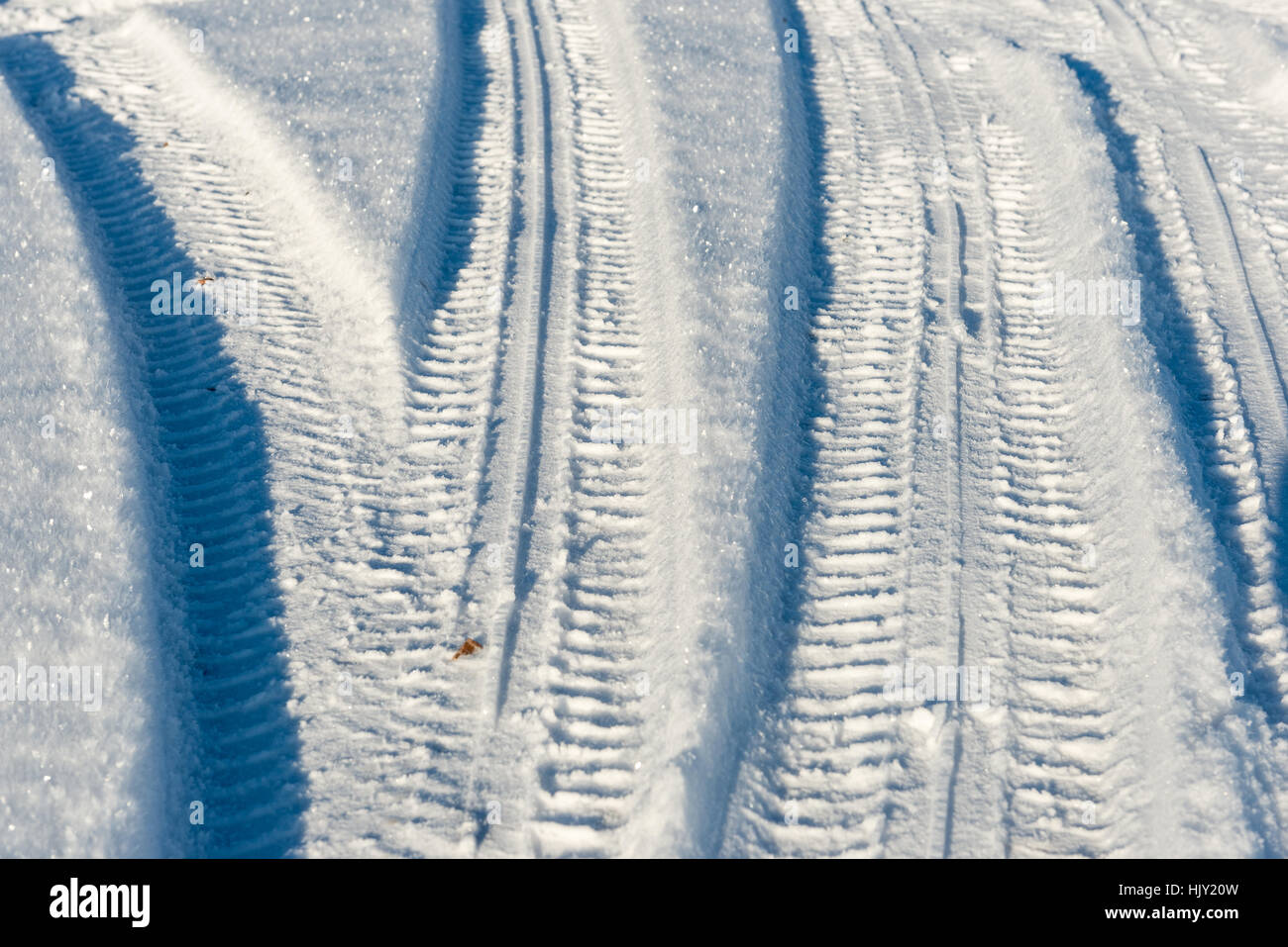 snowy winter road with tire markings and blue sky Stock Photo - Alamy
