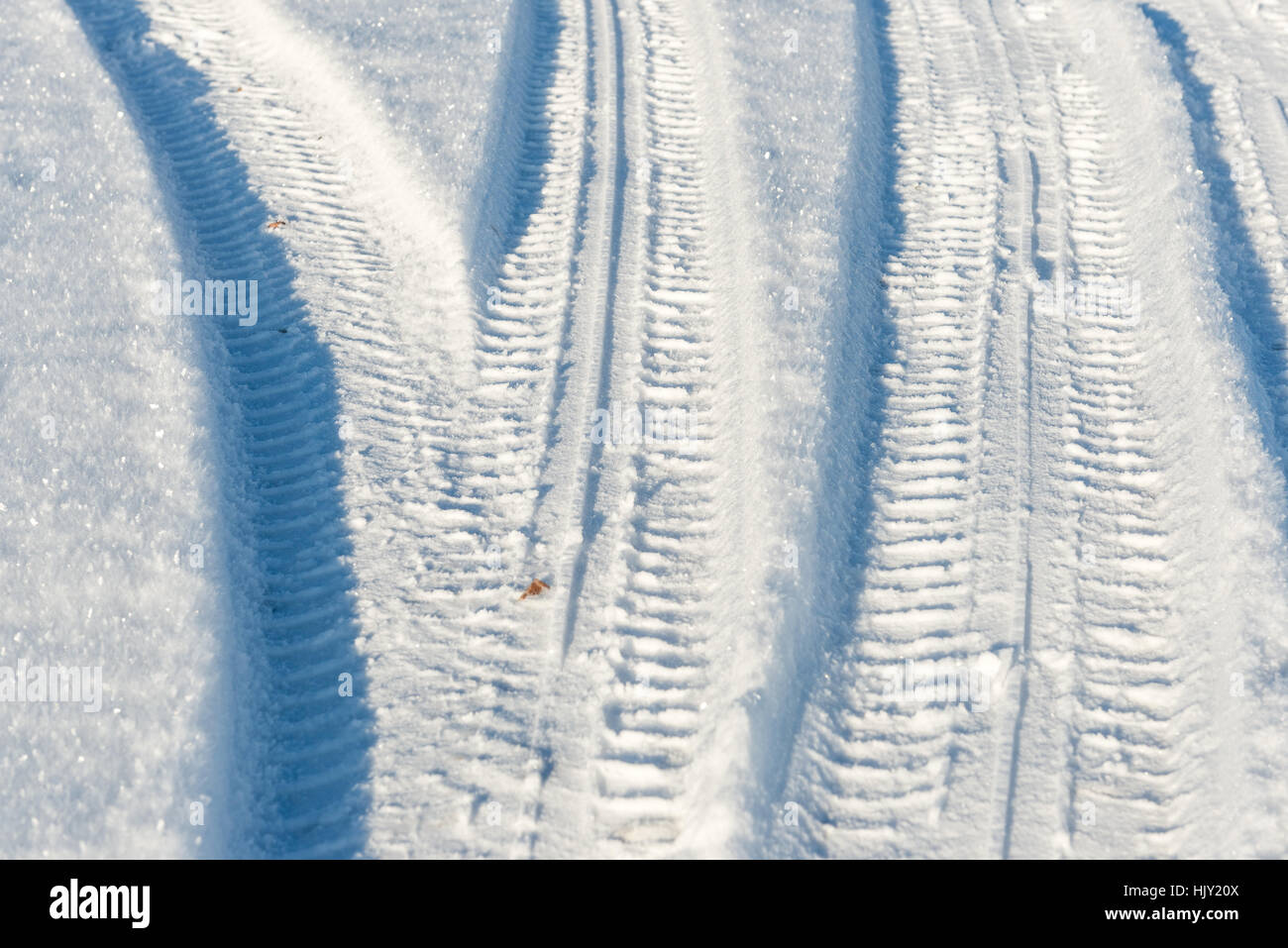 snowy winter road with tire markings and blue sky Stock Photo - Alamy