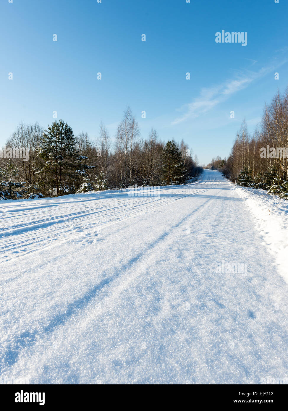 snowy winter road with tire markings and blue sky Stock Photo - Alamy