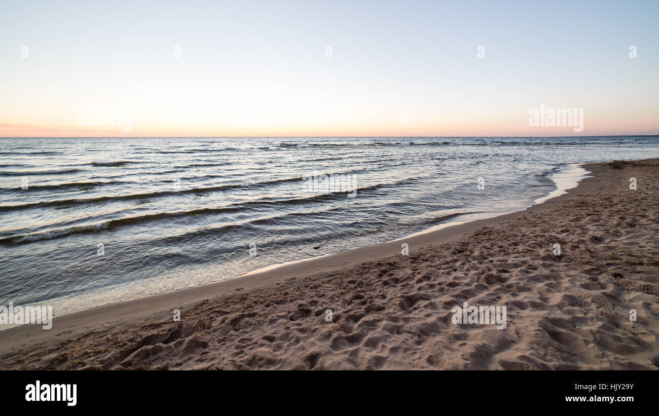 baltic beach in fall with clouds and waves towards deserted dunes ...