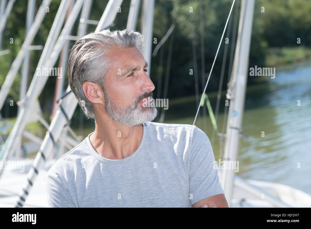 handsome man posing in front of sailing boats and lake Stock Photo - Alamy