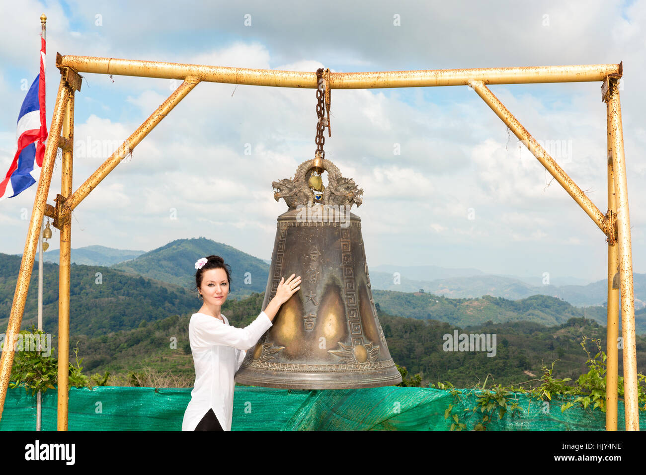 Woman near Thai gong in Phuket. Tradition asian bell in Buddhism temple ...