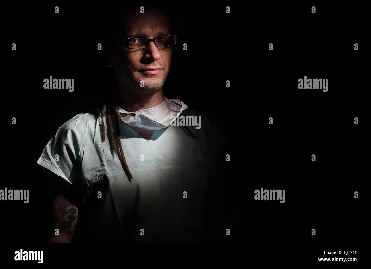 Portrait of male nurse ICU with tattoo and dreadlocks on black ...