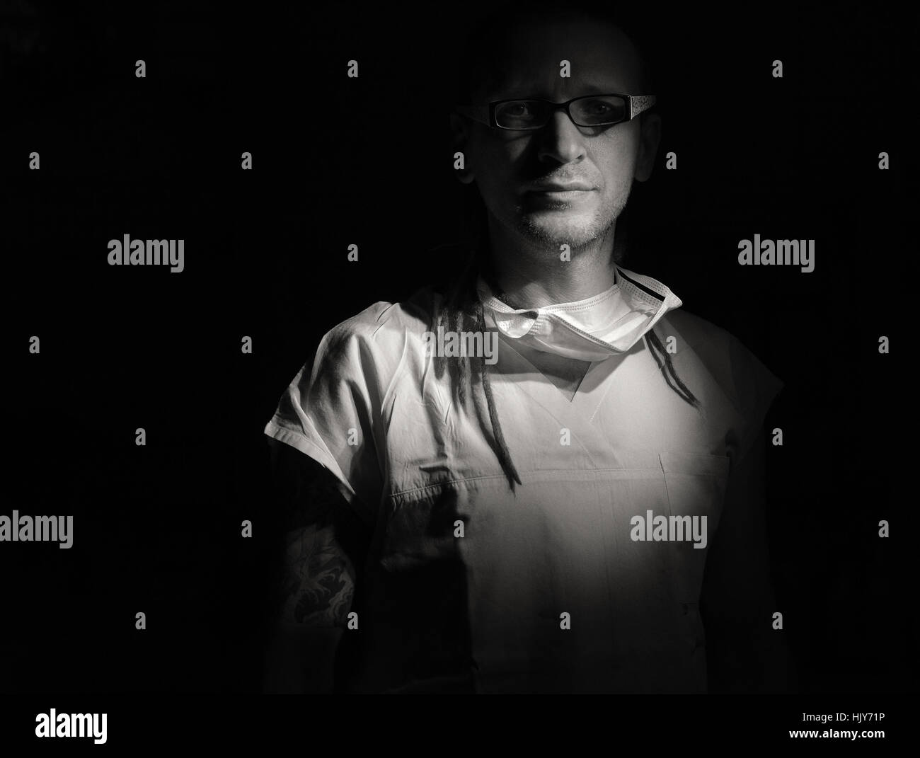 Portrait of male nurse ICU with tattoo and dreadlocks on black ...