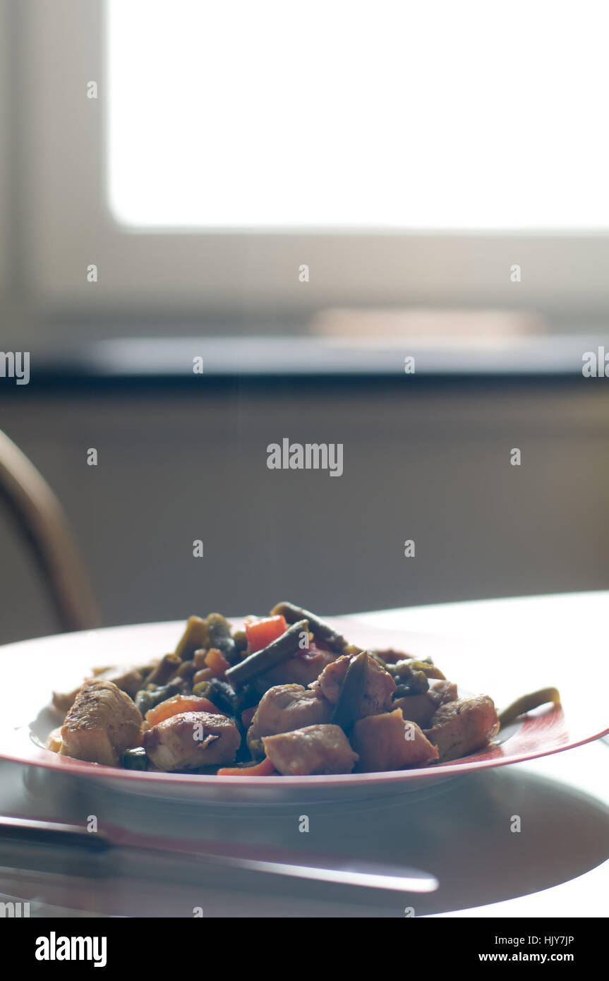 Chicken meat and vegetables on glass table served in red plate Stock ...