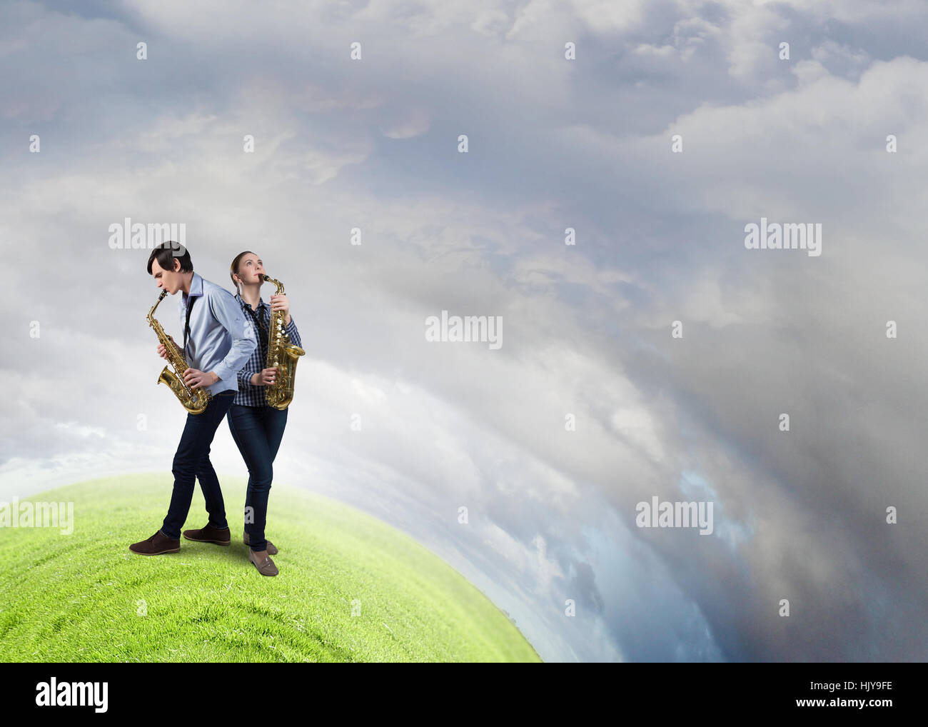 Duet of young man and woman musicians playing saxophones hi-res stock ...