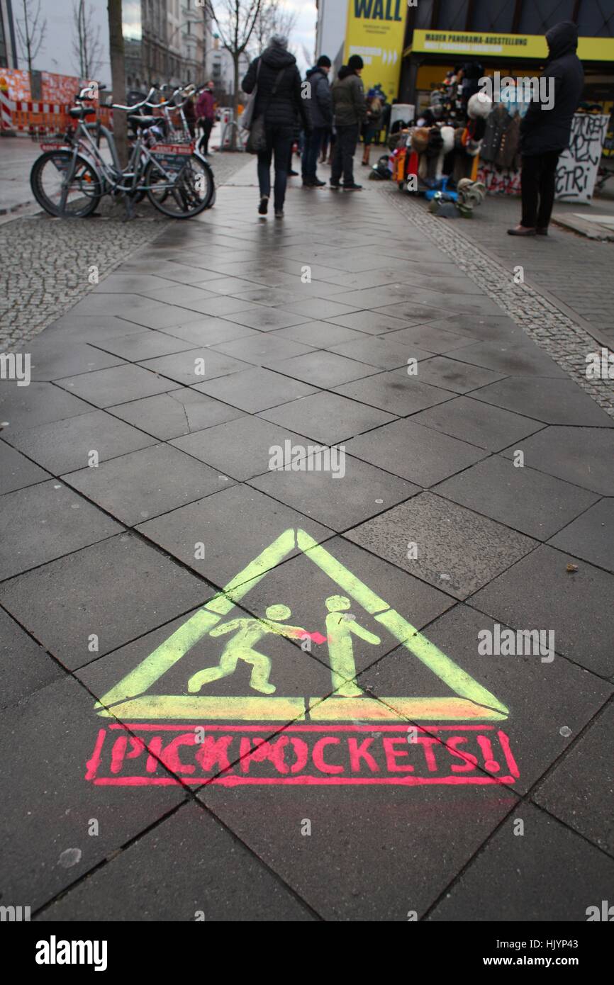 A warning sign in Berlin at Checkpoint Charlie to prevent pickpocketing ...